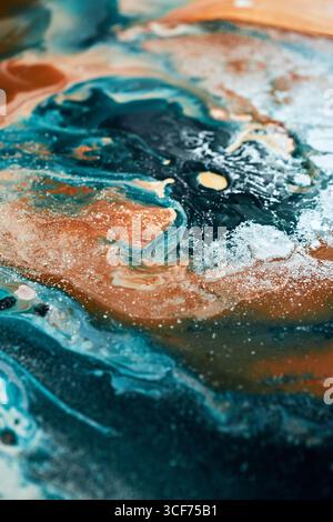 A vertical shot of abstract fluid art in red, black and yellow colors ...