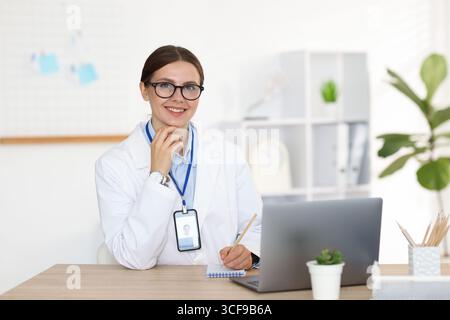 Telemedicine. Doctor making notes while having video call with patient ...