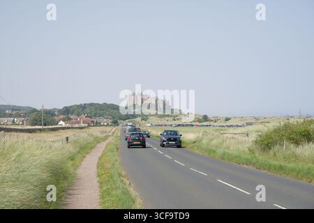 Coast road leading to Bamburgh Castle, Northumberland, UK Stock Photo ...