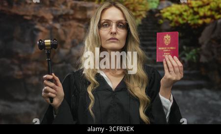Woman in judge uniform outdoors holds norway passport and gavel ...