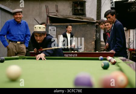 Uygur muslims in Beijing play a game of pool or billiards in the back ...