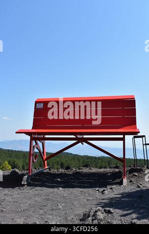 Giant red bench between the black lava rock of the Etna volcano in ...