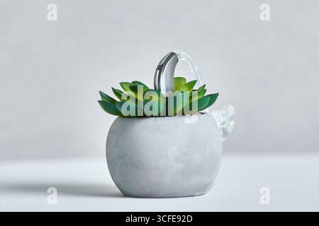 A behind-the-ear hearing aid is positioned on a synthetic model of the ...