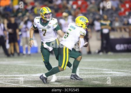 Edmonton Elks quarterback Cody Fajardo, right, hands the ball off to ...