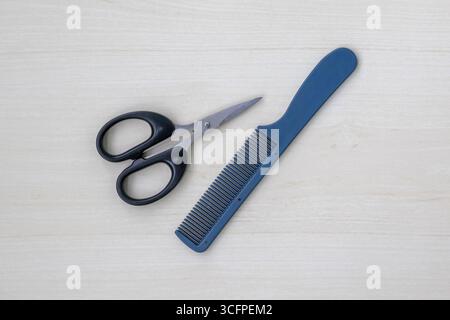 Closeup shot of scissors and hair comb on a beige surface - copy space ...