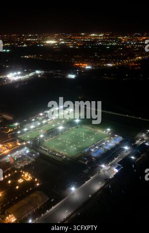 Aerial night view of a brightly lit stadium during a soccer match ...