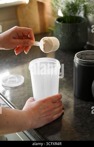 Protein powder. Female hand pouring protein powder in a shaker, food ...