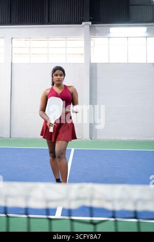 Confident pickleball player holding paddle and ball, ready for a serve ...