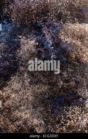 This image shows a large, tangled pile of brown and blue fishing nets ...