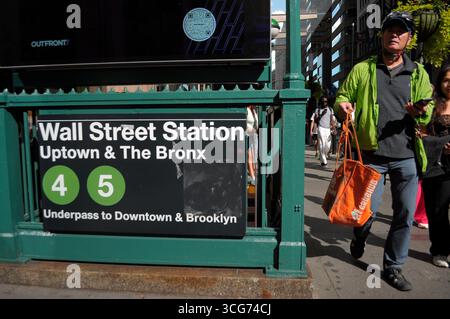 A person walks past the Wall Street subway station in the Financial ...