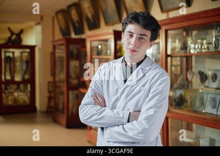 Young professional scientist man wearing white coat over isolated ...