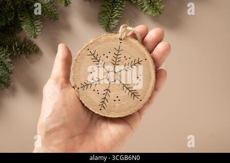 Handmade pyrography snowflake ornament on a Christmas tree with white ...