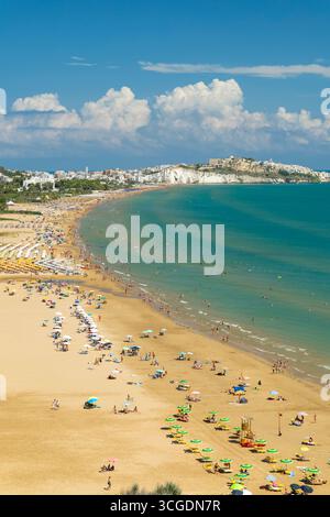 colorful umbrellas and tourists crowd the sand line at Praia do Forte ...
