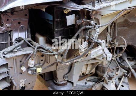 Technician testing electronic components and wiring inside disassembled ...