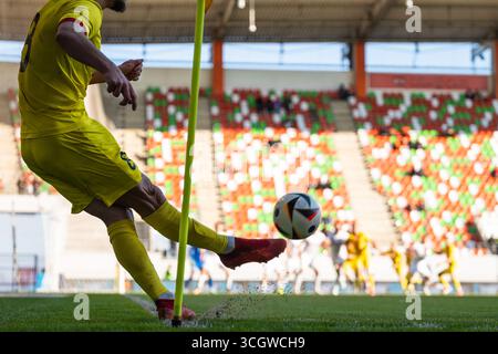 Footballer takes the corner. Detail of player's legs and the ball ...