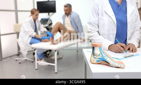 Diagnostic medical sonographer examines human ankle using high ...