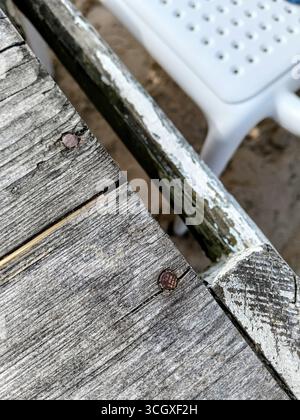 A detailed view of weathered wooden deck planks arranged in parallel ...