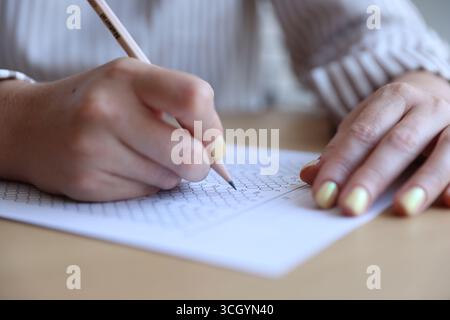 Student filling out multiple choice test at table, closeup. Passing ...