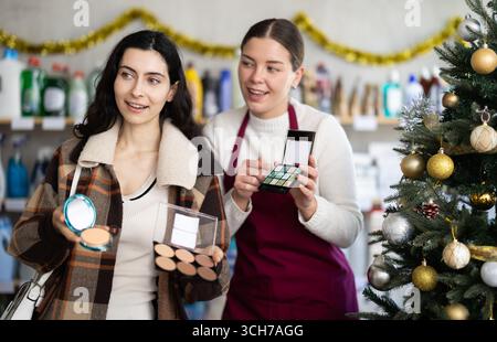 Girl consultant helps female buyer choose eye shadow set Stock Photo ...