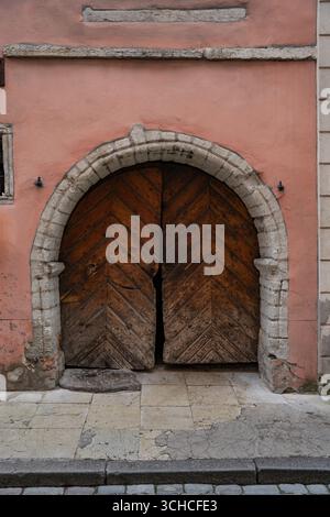 An arched wooden door in stone building Stock Photo - Alamy