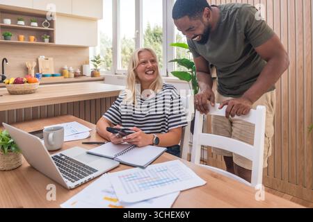 Freelance and remote workers. Smiling young woman pouring coffee in a ...