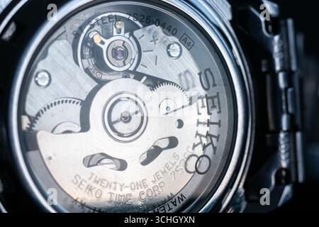 Gears and pendulum in wrist watch close up, transparent glass back of ...