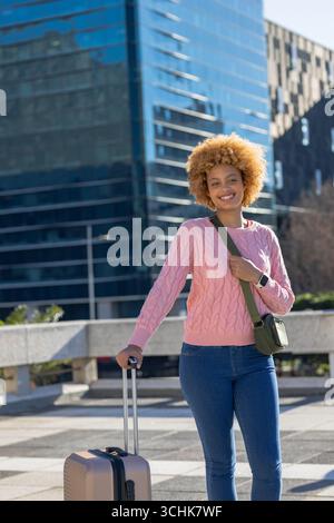 Woman traveler with suitcase in sweater yawn, stretching and raised ...