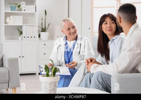 Female fertility doctor showing sonogram image after IVF to young ...