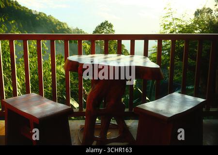 A cabin balcony view of greenery with blue sky and small white clouds ...