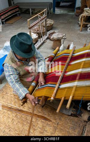 Master weaver Rafael Maldonado weaves on a backstrap loom in the Tahuantinsuyo Weaving Workshop ...