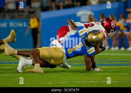 Utah tight end Dallen Bentley, center, is tackled by Kansas linebacker ...