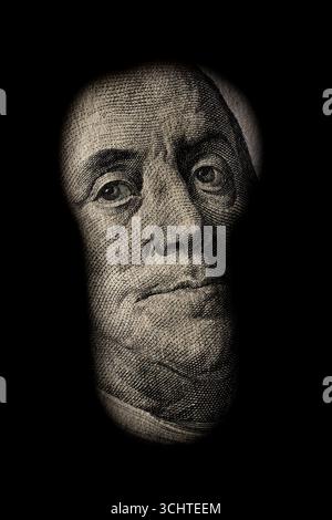 Economy concept. A man looks through a magnifying glass at charts and ...