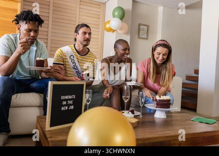 Celebrating new job, diverse friends enjoying party with cake and ...