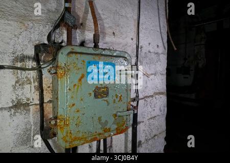 equipment, wiring and pipes in an abandoned underground bunker, shabby ...