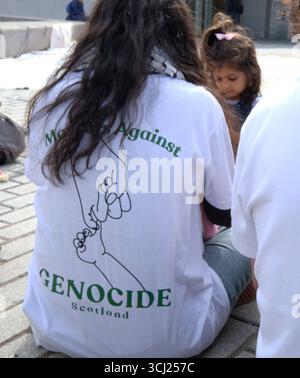 Campaigners from Mothers Against Genocide participate in a "die-in ...
