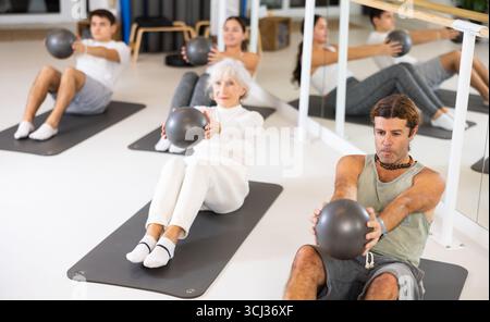 Group of different people doing exercises with roller Stock Photo - Alamy