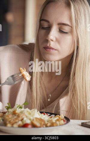 Beautiful sad woman in cafe eating salad Stock Photo - Alamy