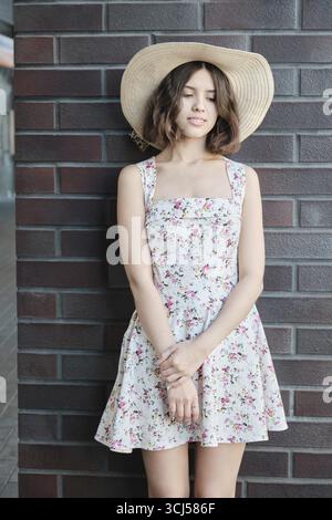 cute young woman near bricks wall in european city smiling, looking ...