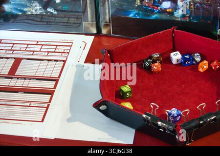 Different colorful role playing dice on table with blurry storage ...