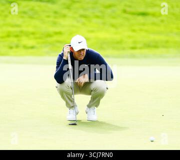 Rory McIlroy of Northern Ireland lines up a putt on the 17th green ...