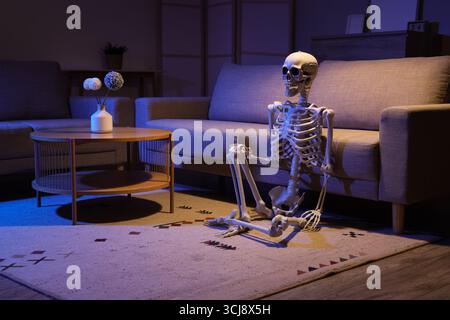 Human skeleton model on carpet near sofa in living room at night Stock ...
