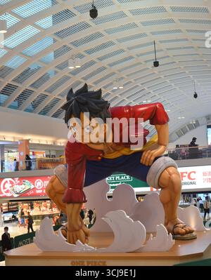 On podium inside a shopping arcade displays a large inflatable figure ...