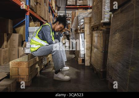 Tired stress young teen women worker labor rest in factory warehouse ...