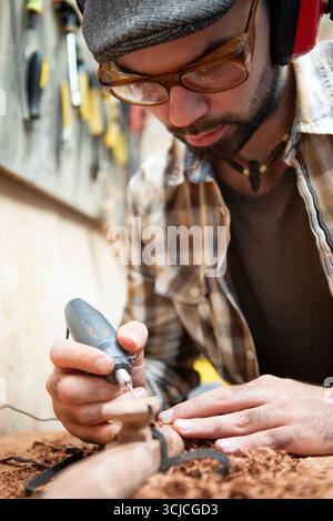 Worker uses tools on wooden beams joins structure they stand on ladder ...