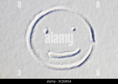 Smiley face drawn on snow background Stock Photo - Alamy
