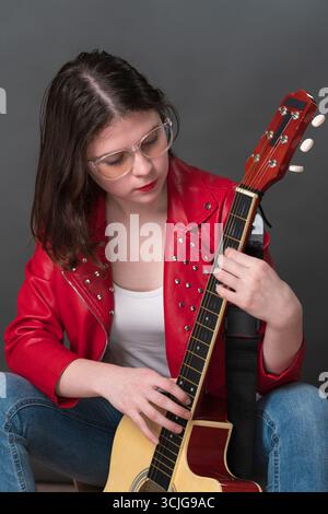 Woman guitarist in process of tuning her Spanish six string acoustic ...