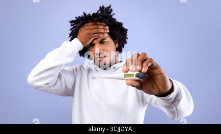 Sick black teenager showing thermometer with high temperature numbers ...