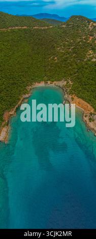 An aerial of a small lake surrounded by rocky mountains in the ...