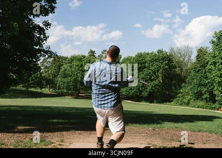 Man playing disc frisbee golf Stock Photo - Alamy