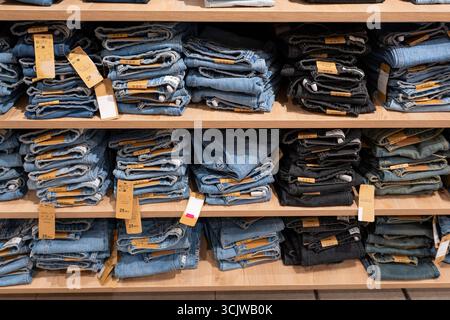 Colorful stacks of folded clothing arranged neatly with price signs in ...